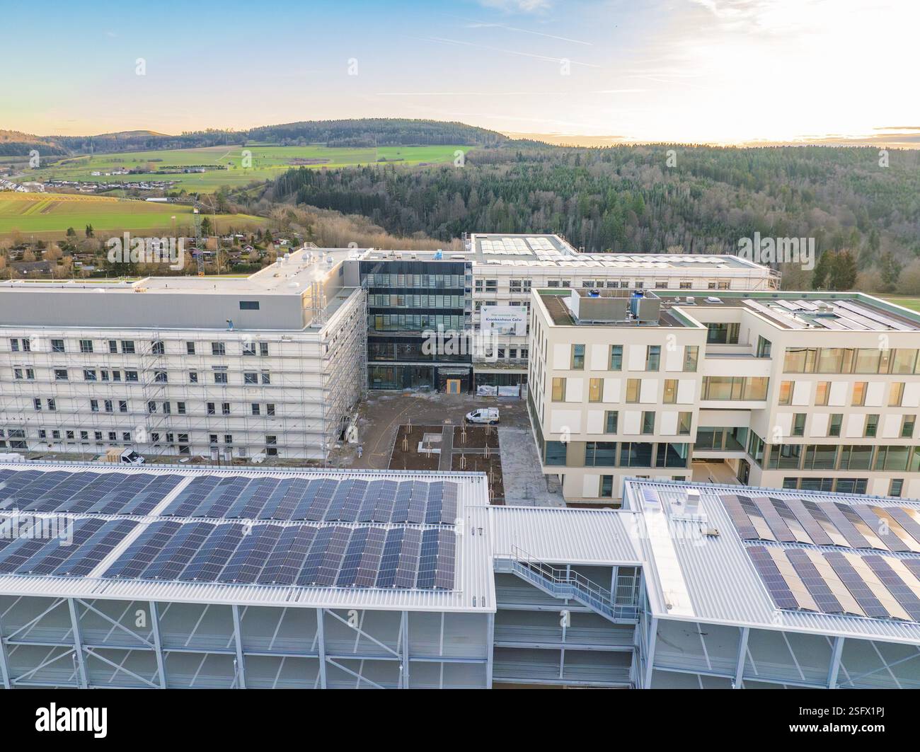 Modern building complexes with solar panels near wooded hills, new Calw ...