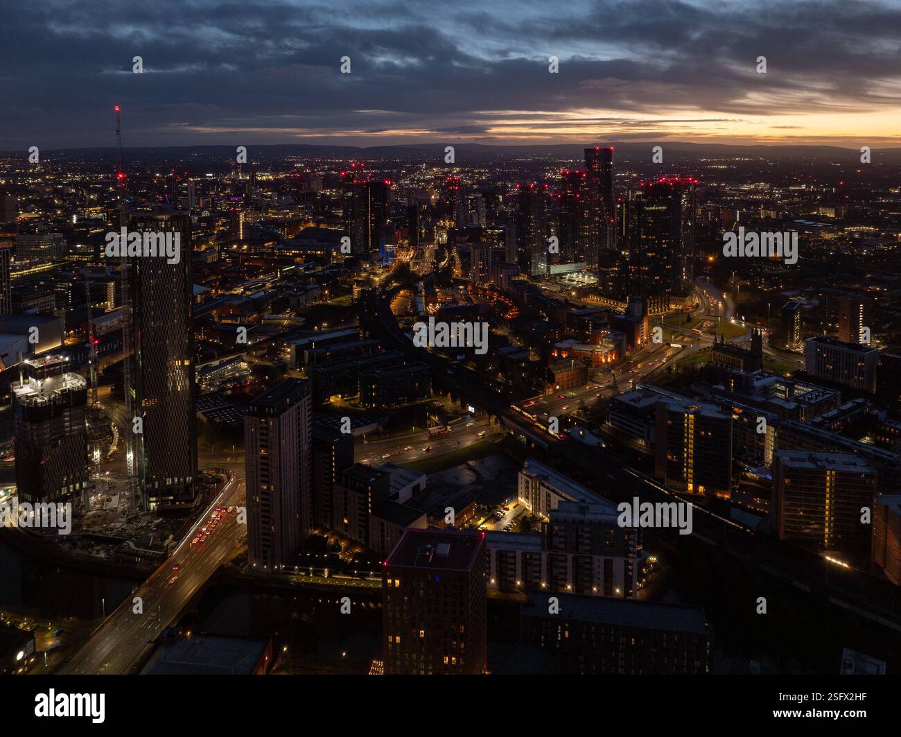 Aerial view of Manchester at dusk, showcasing illuminated skyscrapers ...
