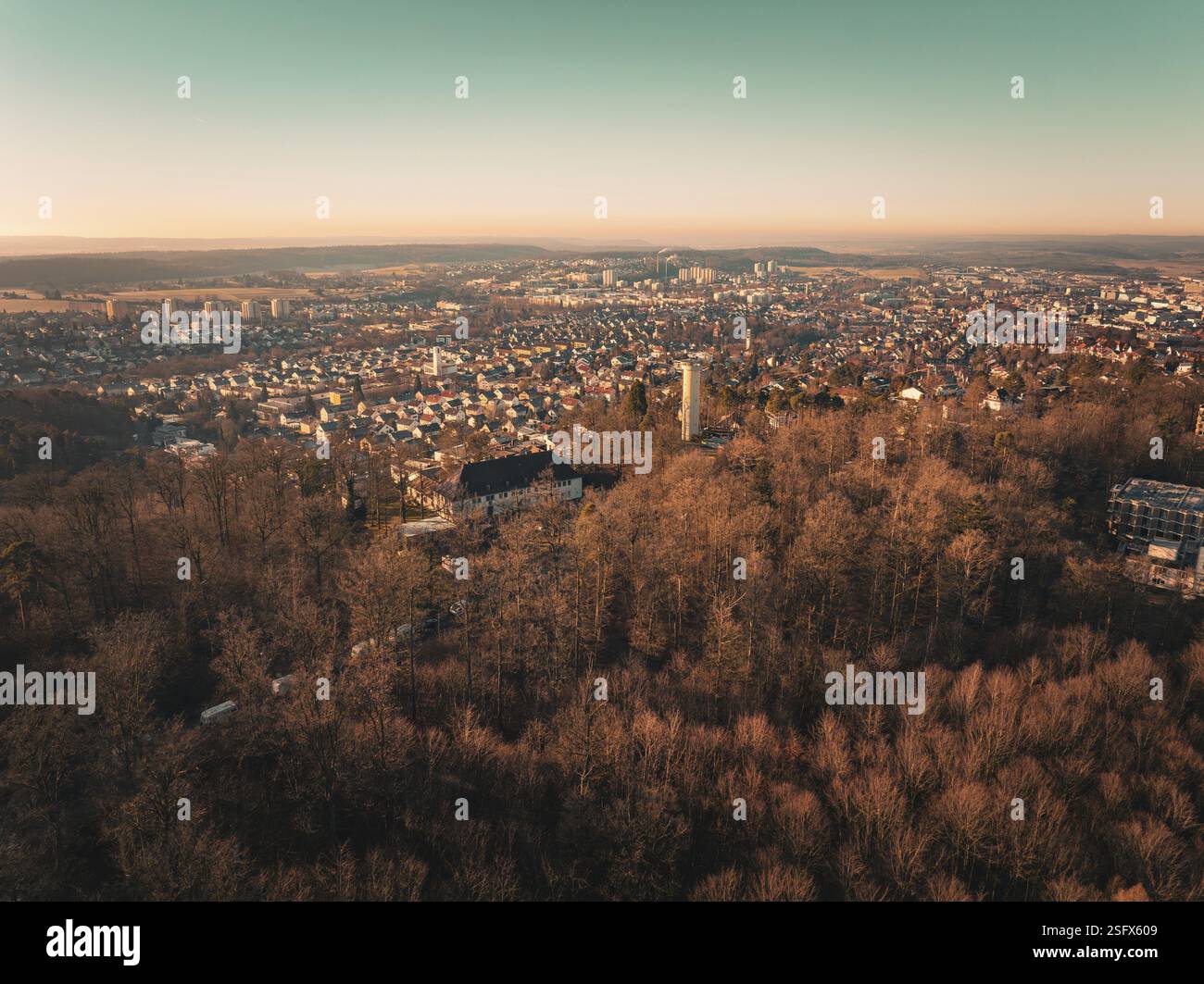 Bird's eye view over a wooded landscape and the town behind with ...