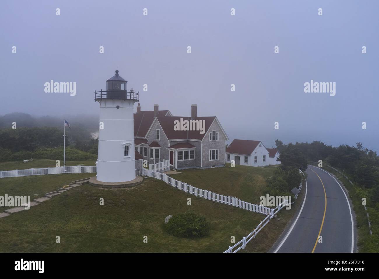 Nobska lighthouse and empty road in fog near Woods Hole, Cape Cod ...