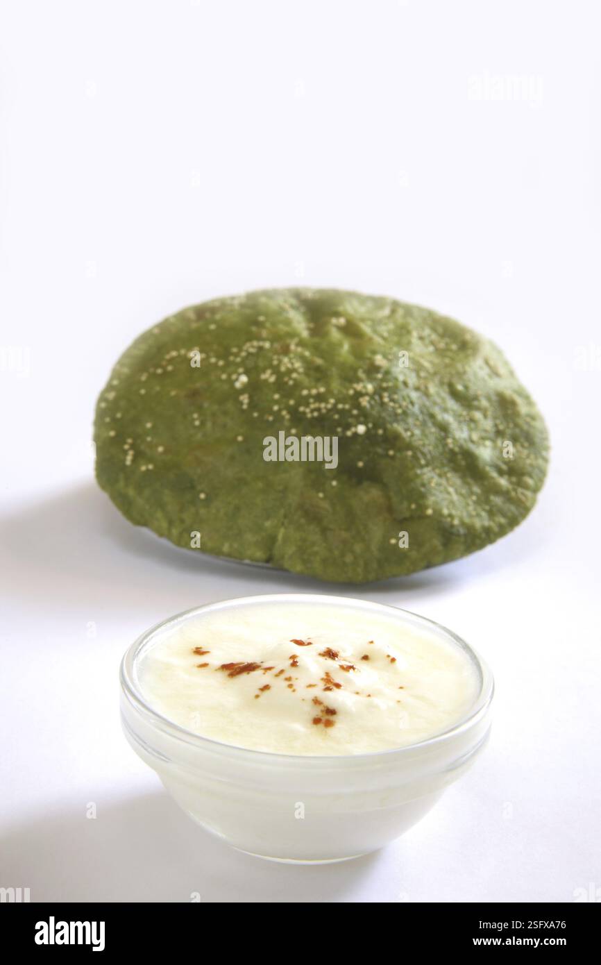 Indian cuisine, fast food crispy Palak Spinach Puri with curd served in ...