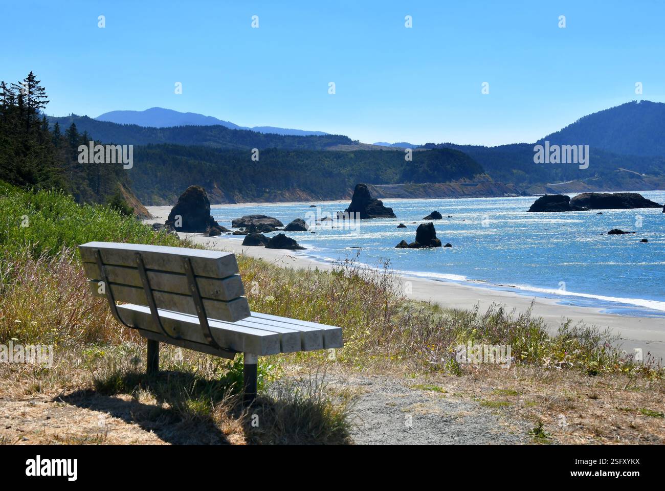 Bench sits facing sea stacks and curving Highway 101, on Battle Rock ...