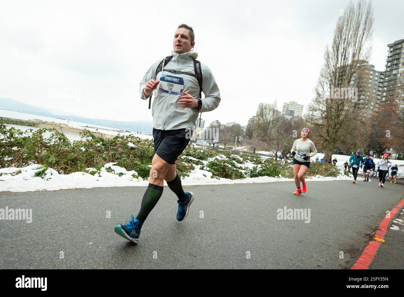 Vancouver, Canada - 9 Feb, 2025. Runners along the sea wall with snow ...