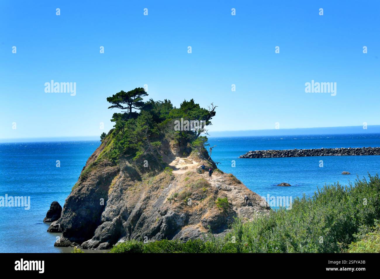 Visitors climb the famous and historic Battle Rock at Battle Rock State ...