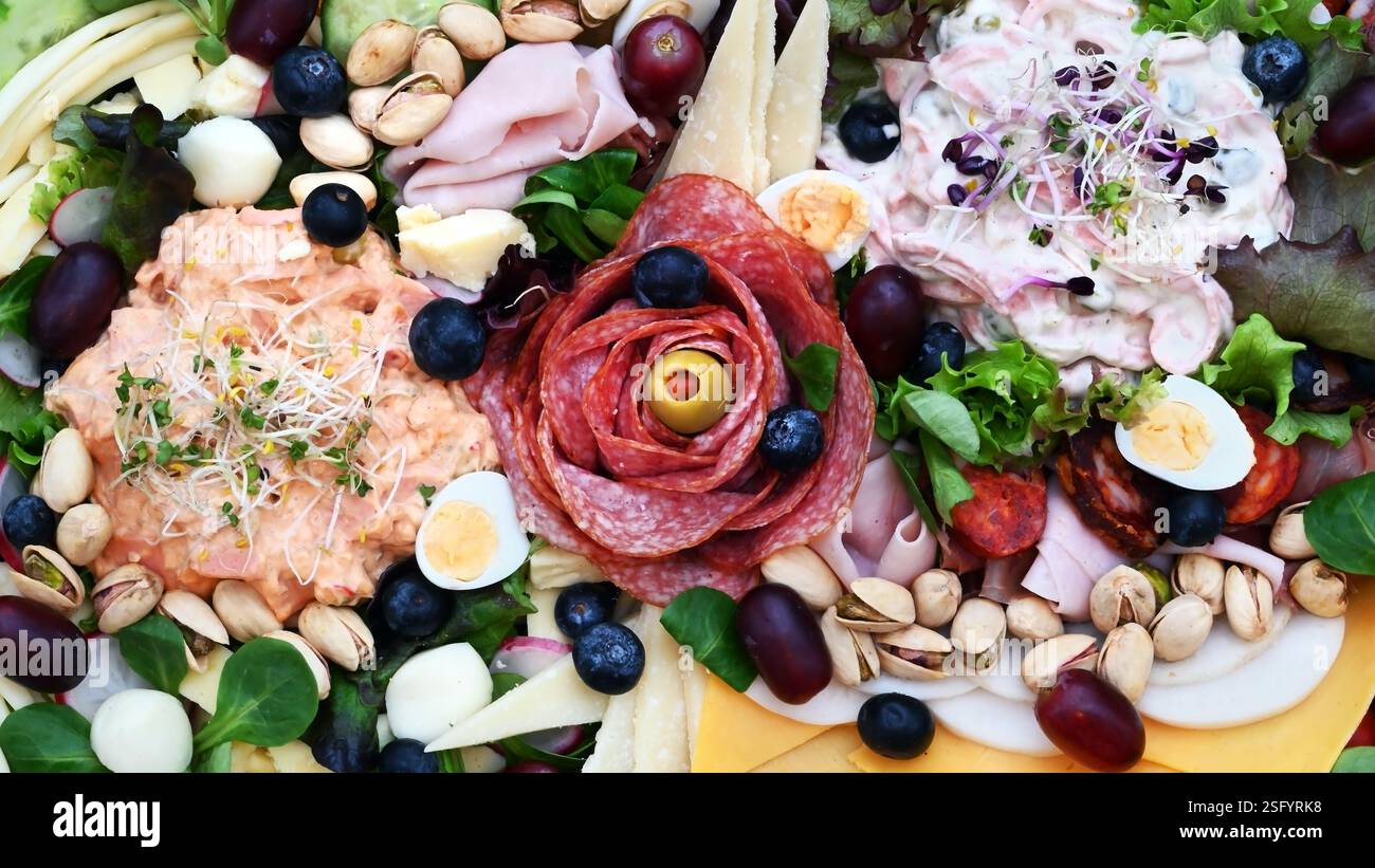 Delicious assorted meat, cheeses, nuts and fruits on a salad platter in widescreen format Stock ...