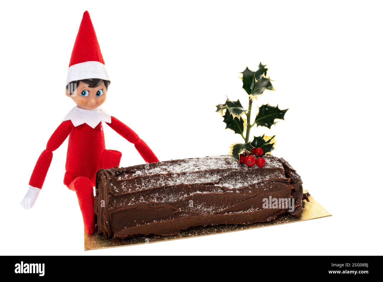 A Christmas pixie elf sat beside a chocolate yule log. - white ...