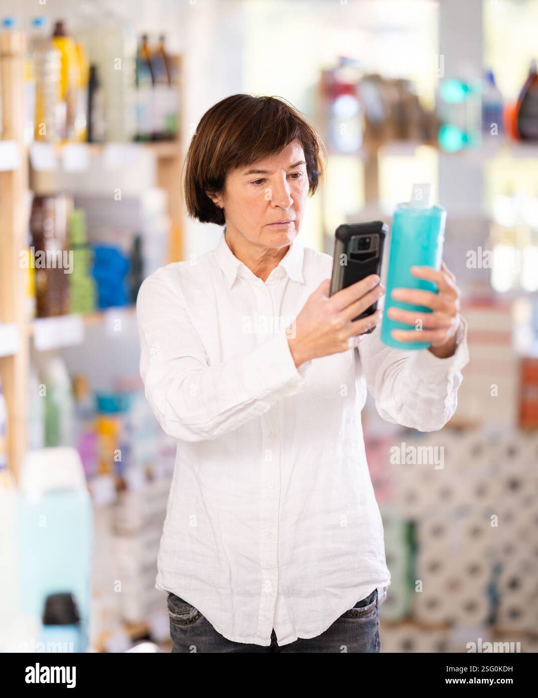 Checking expiration date of shampoo or shower gel - female shopper ...