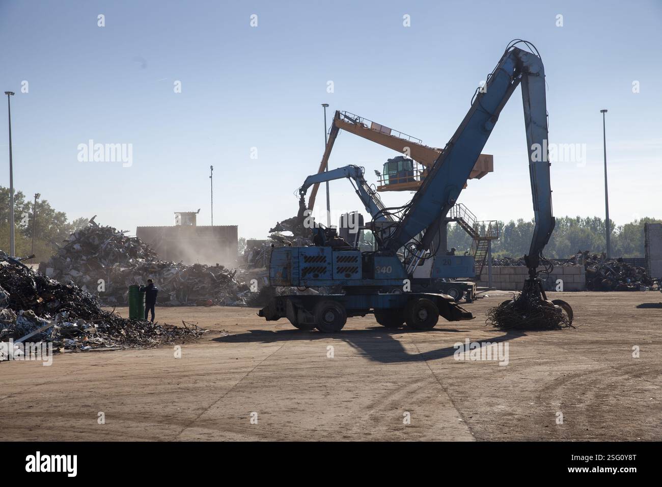 Large excavators work on scrap metal for recycling, sunny day Stock ...