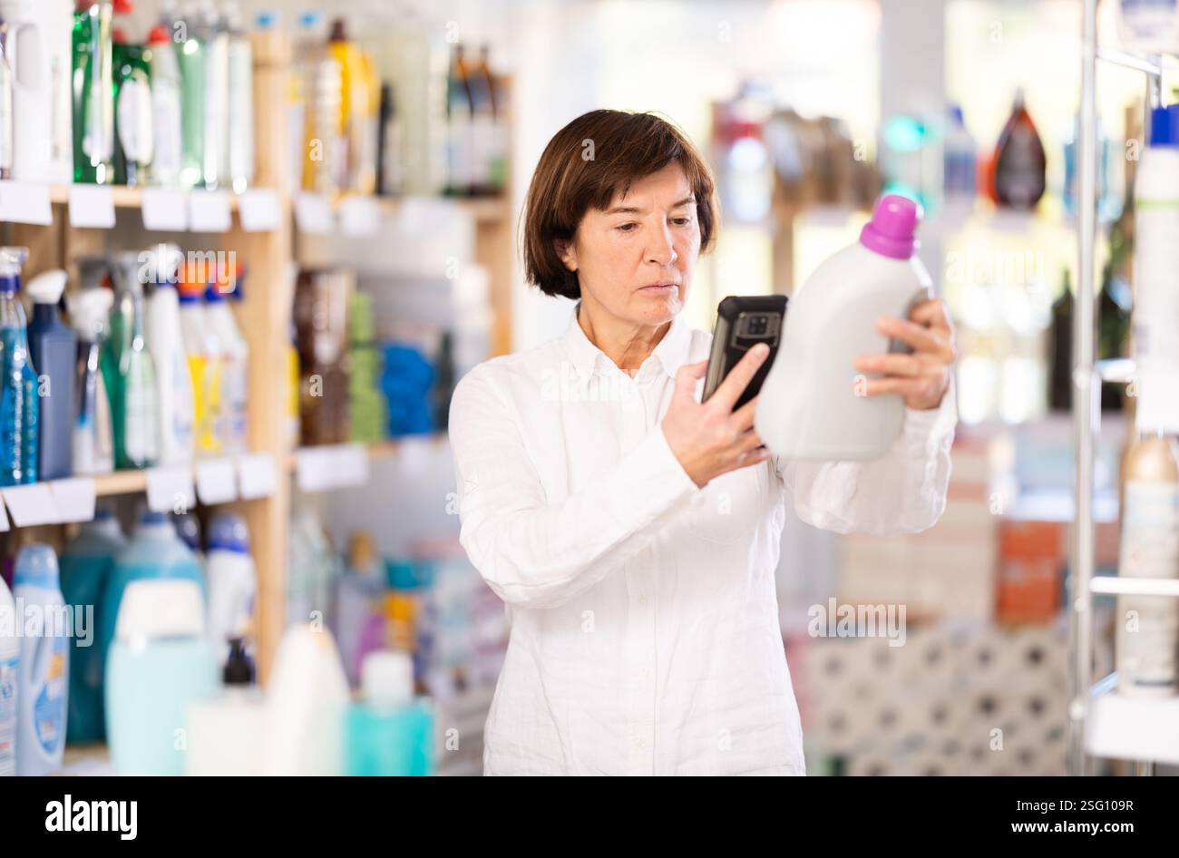 Checking expiration date of detergent - male shopper scans QR code on ...