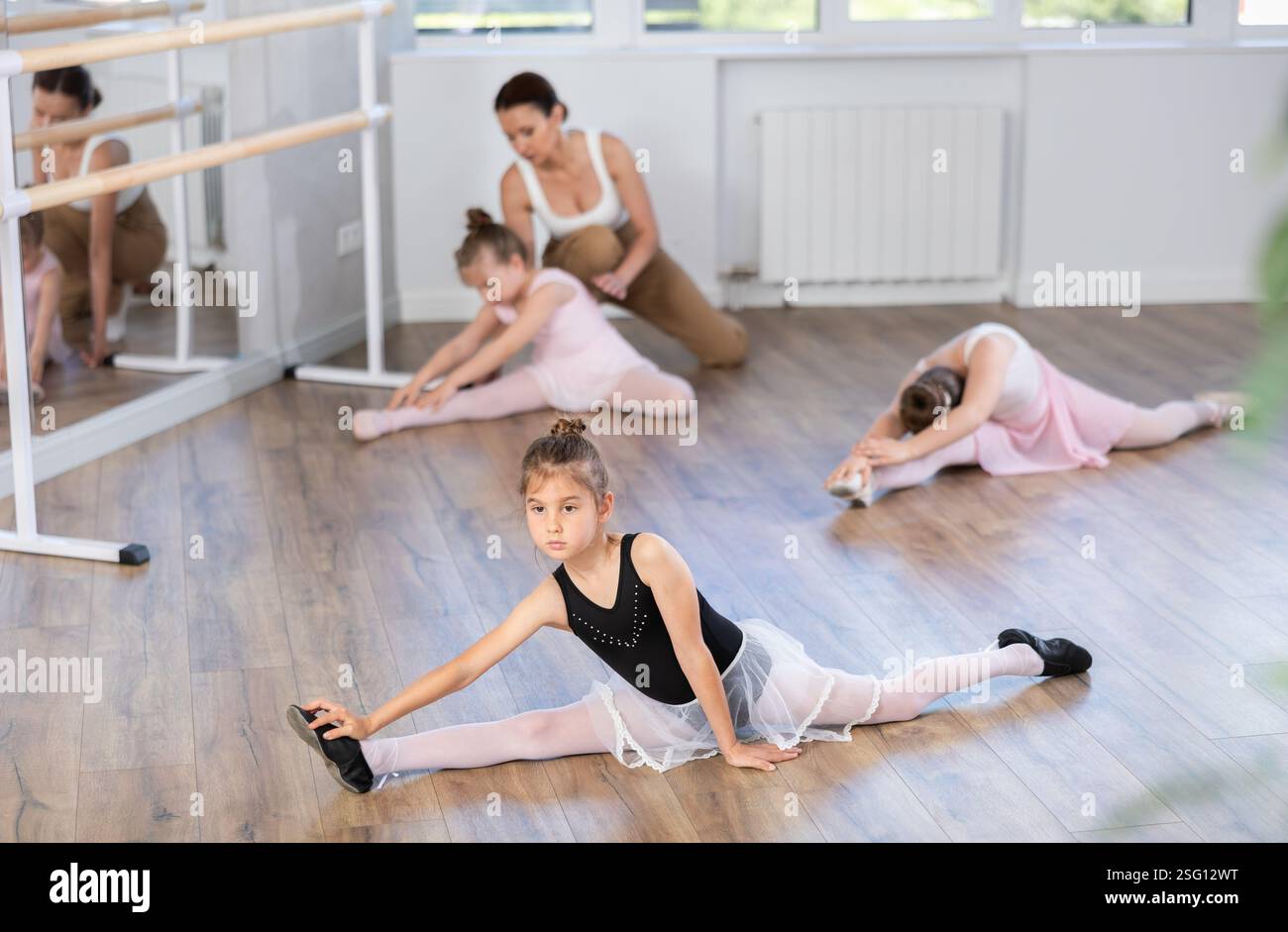 Little girls ballerinas learn to do the splits in dance class Stock ...
