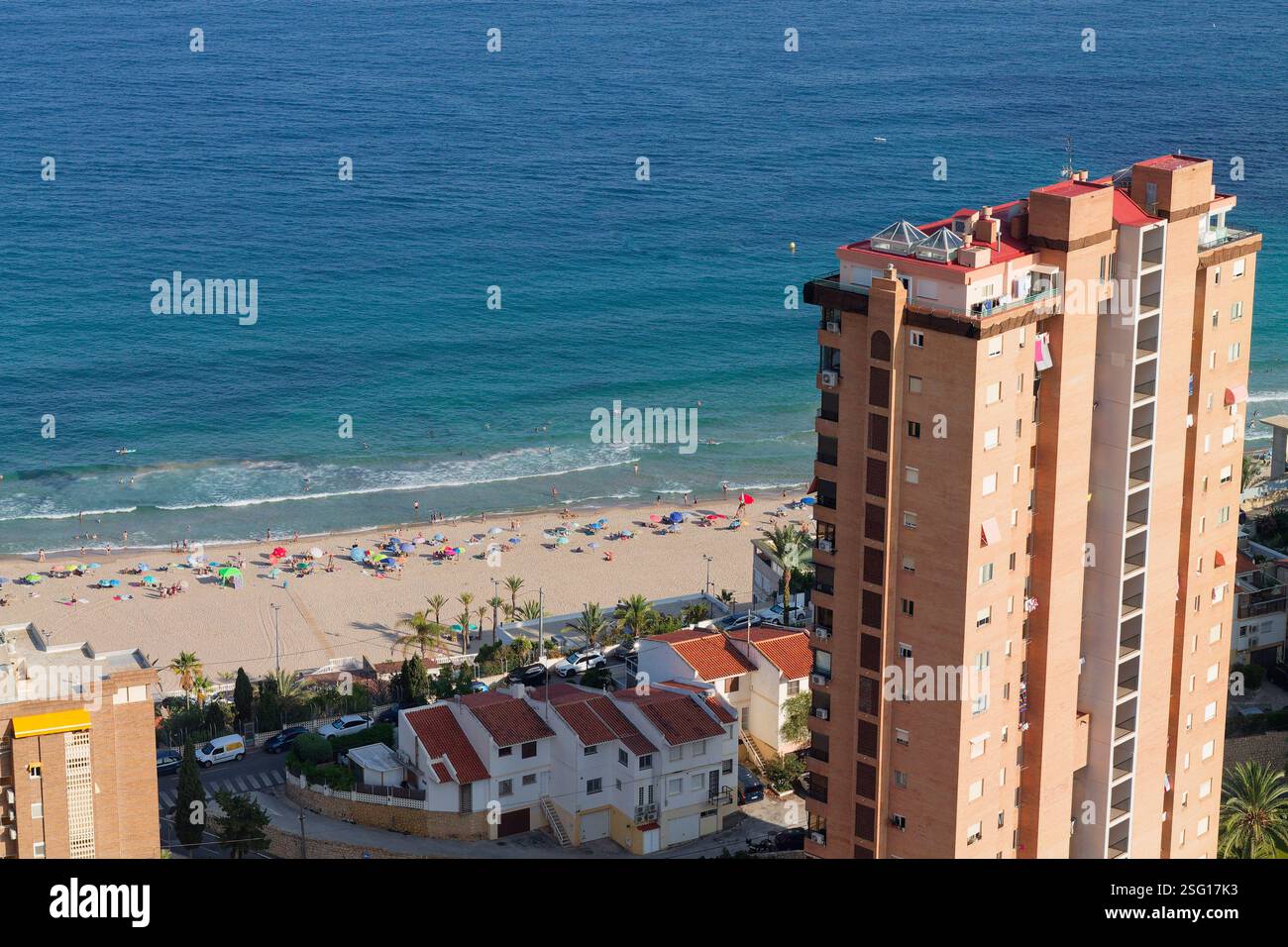 Aerial view of a beach with people sunbathing and colorful umbrellas ...