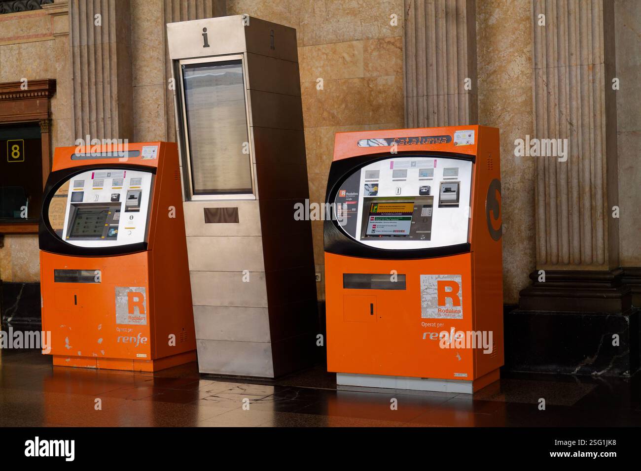 Two orange ticket vending machines for Renfe, a Spanish train service ...