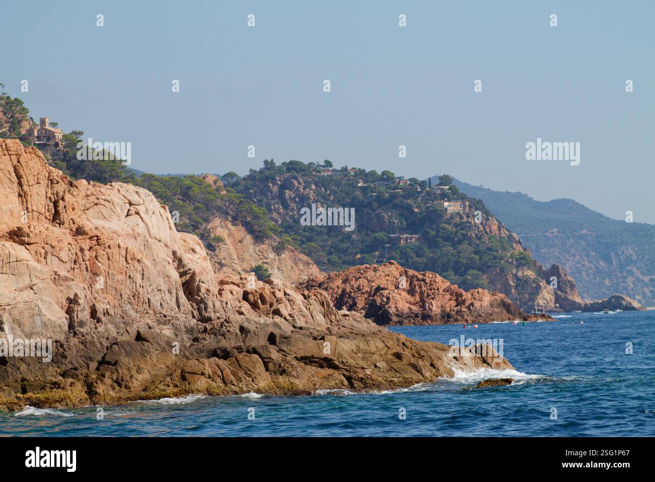 A scenic coastal view featuring rocky cliffs and a clear blue ocean ...