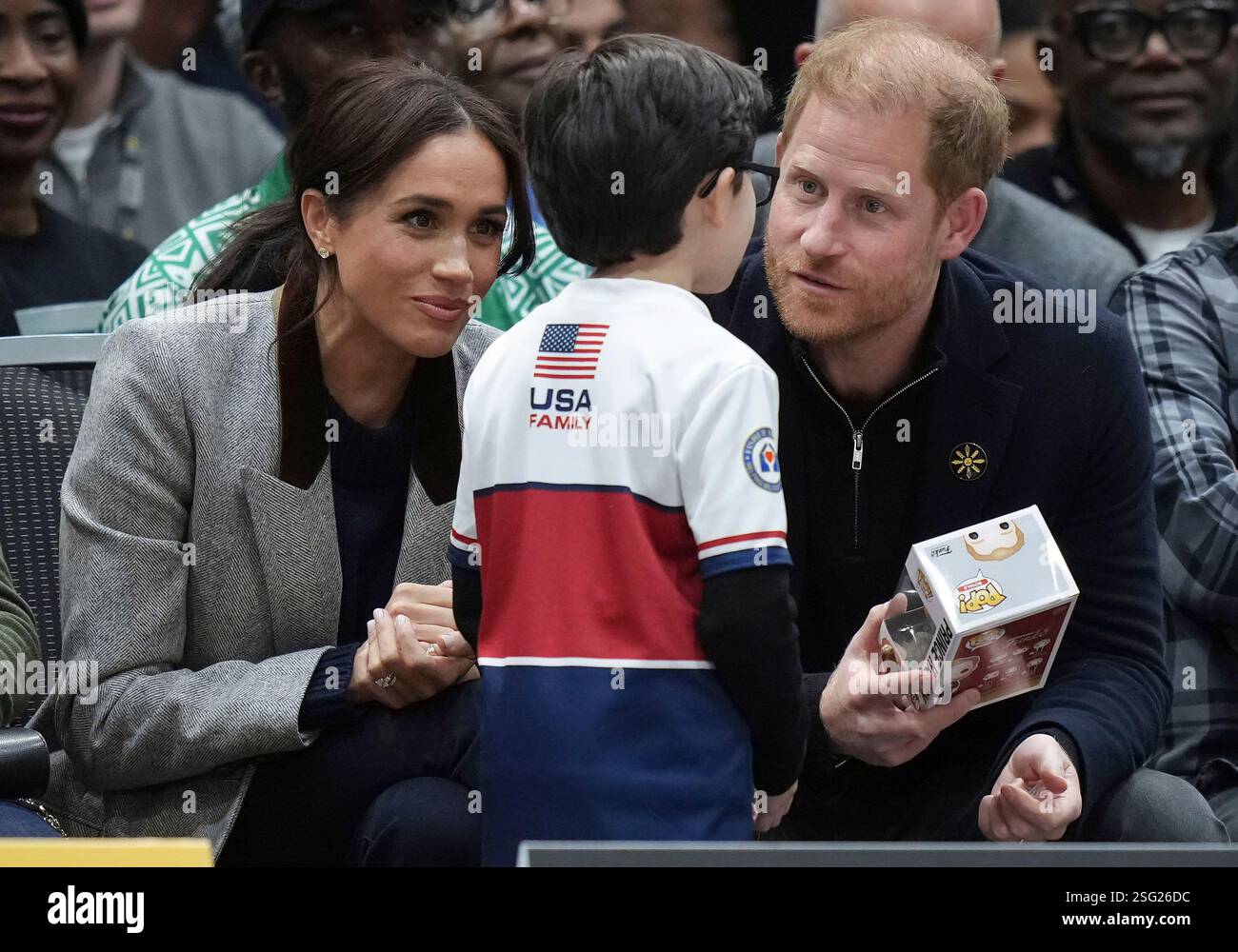 Britain's Prince Harry holds a toy figurine of his likeness that he ...