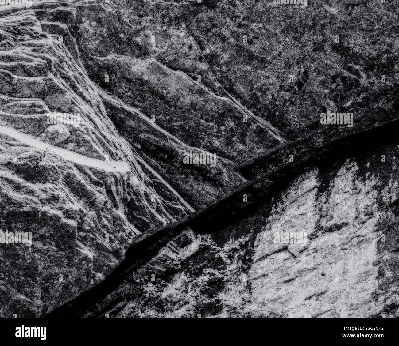 Black and white abstract close-up of textured rock formations with deep ...