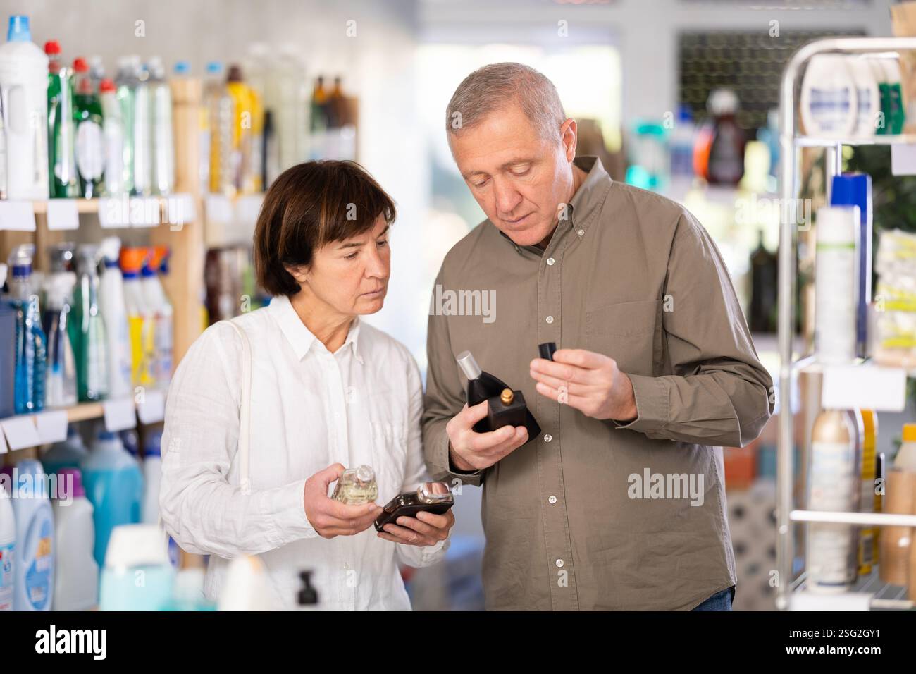 Couple man and woman choosing perfume in store Stock Photo - Alamy