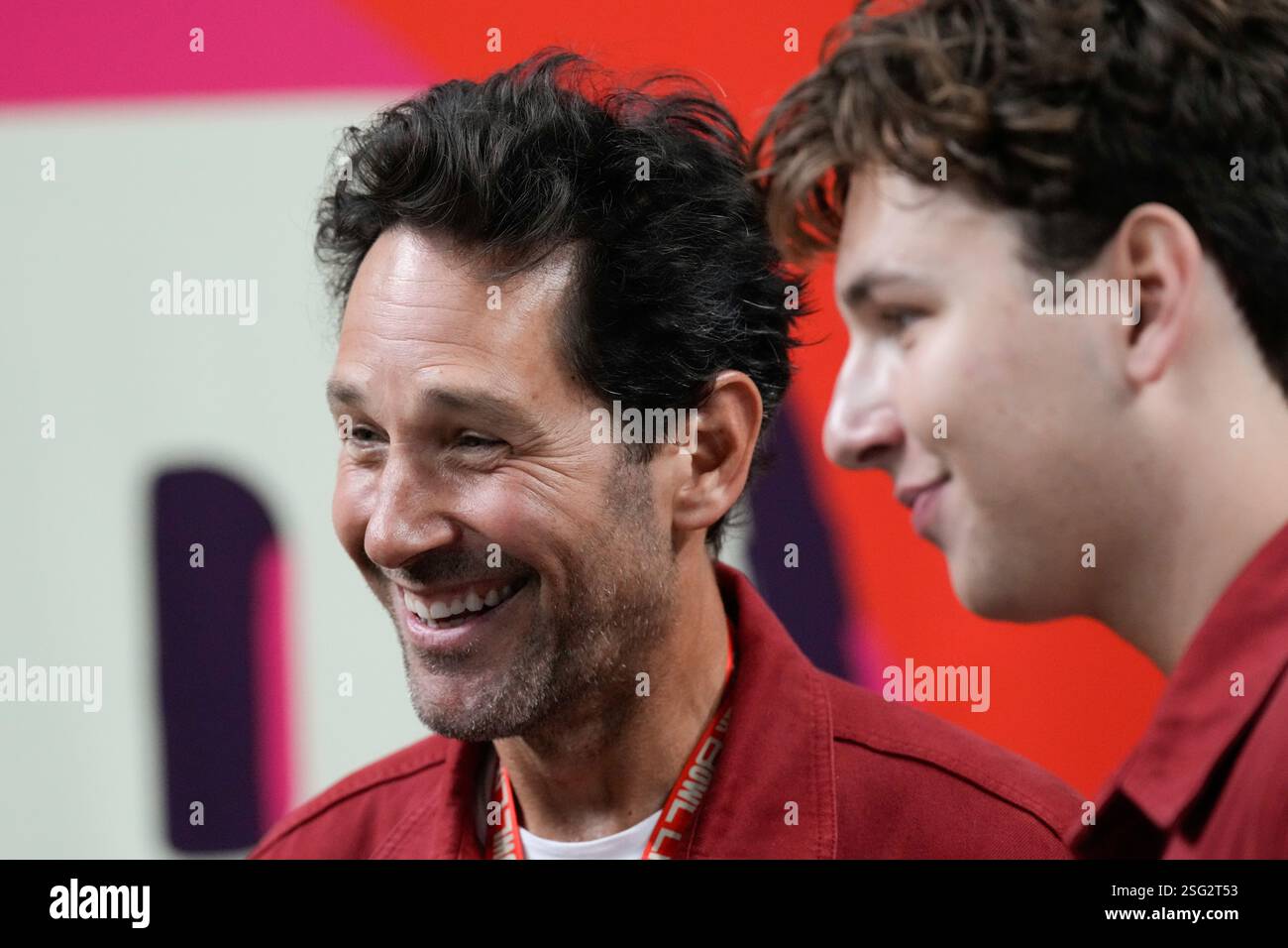 Paul Rudd, left, smiles as he stands on the field before the NFL Super ...