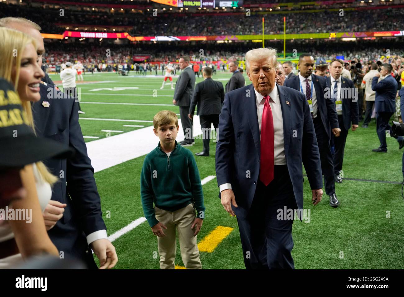 President Donald Trump, from right, walks on the field with grandson ...