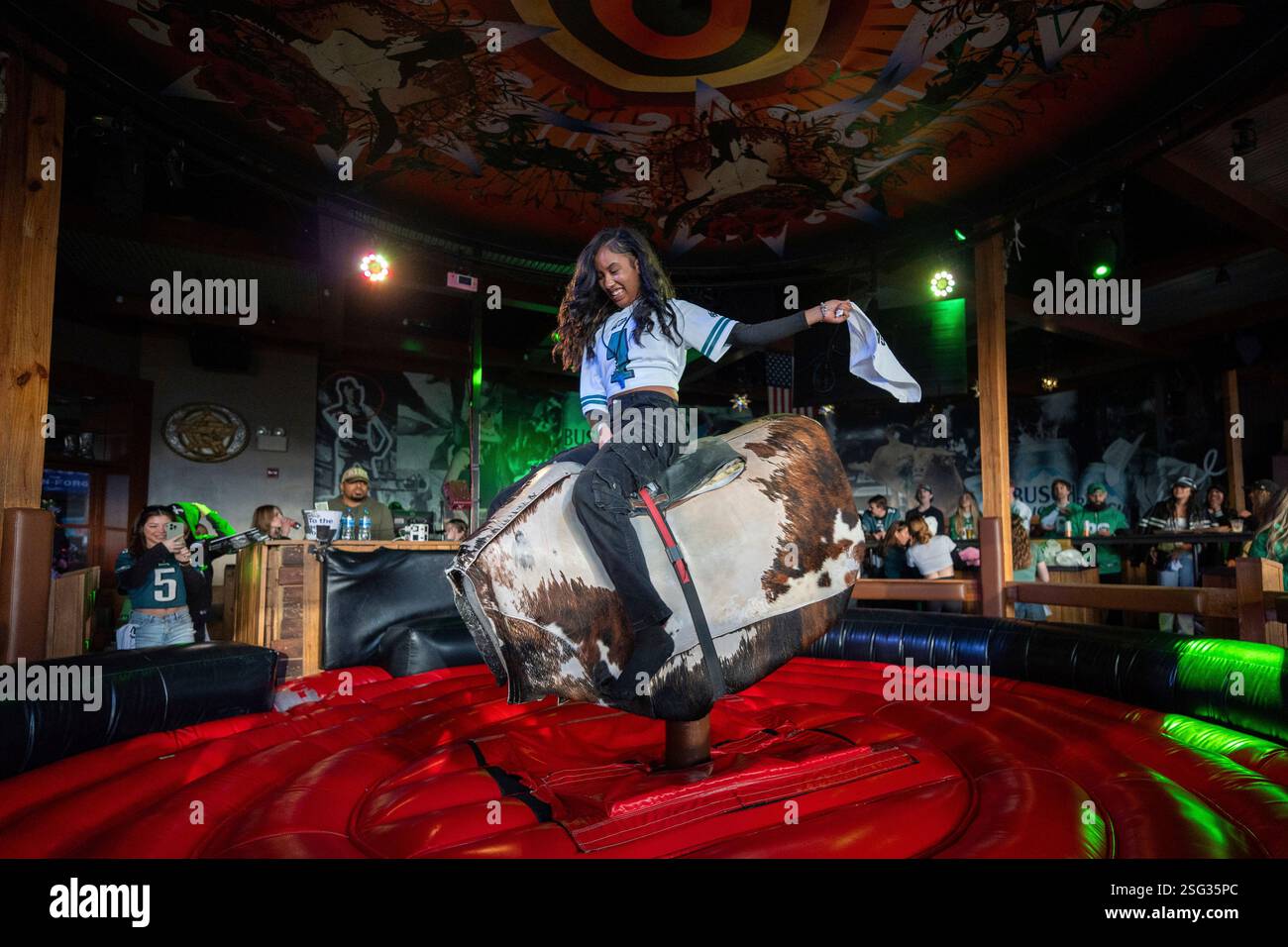 A Philadelphia Eagles fan rides the mechanical bull at the PBR Philly ...