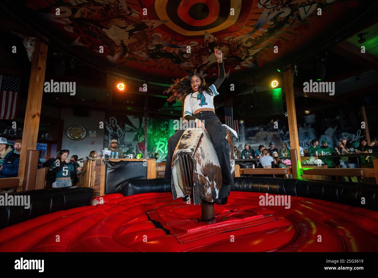 A Philadelphia Eagles fan rides the mechanical bull at the PBR Philly ...