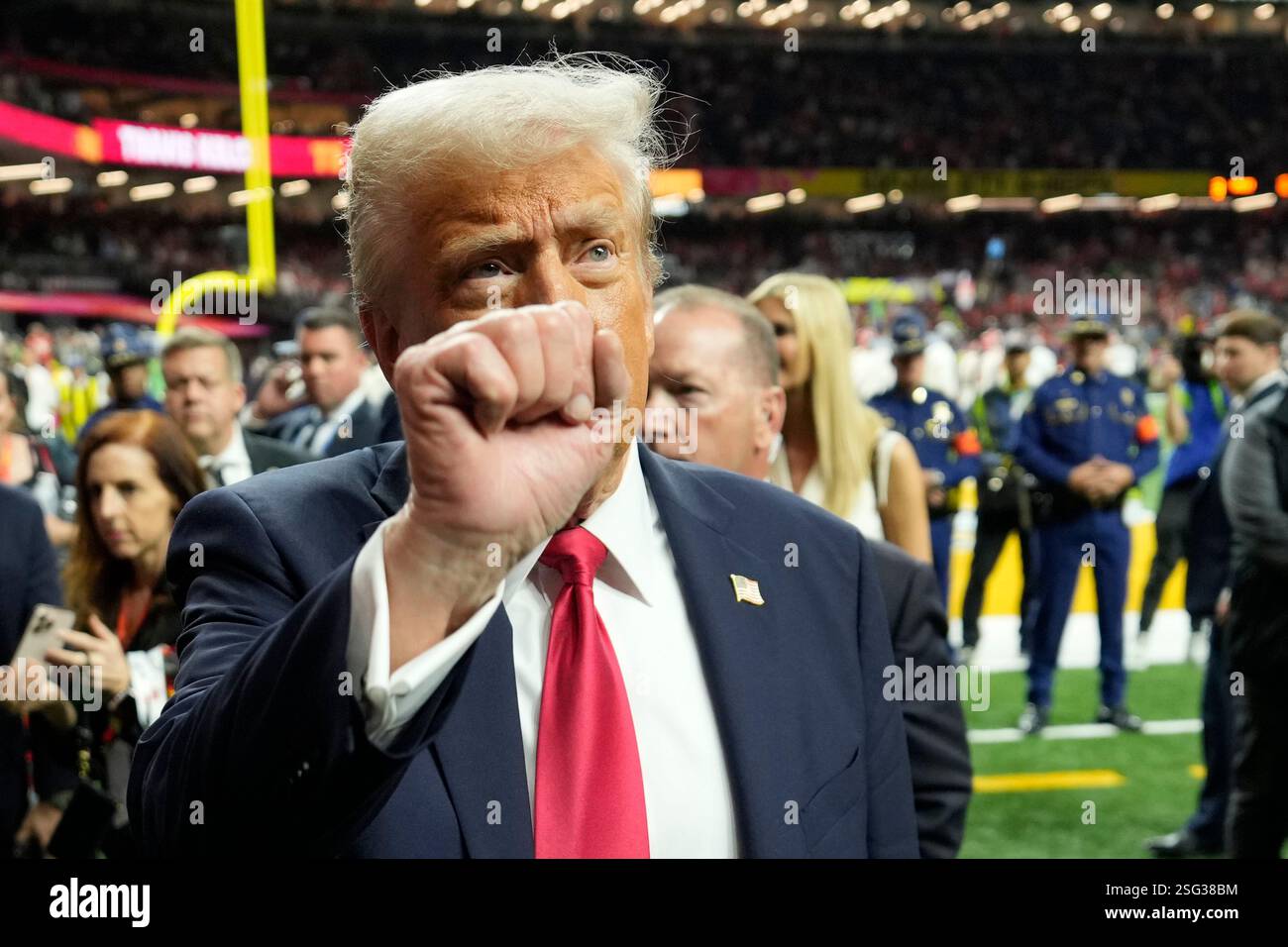 President Donald Trump gestures as he walks on the field before the ...