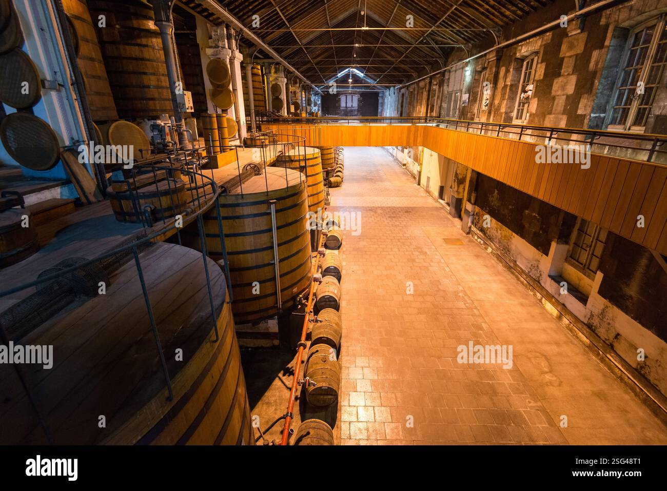 Historic distillery interior showcasing large wooden fermentation tanks ...