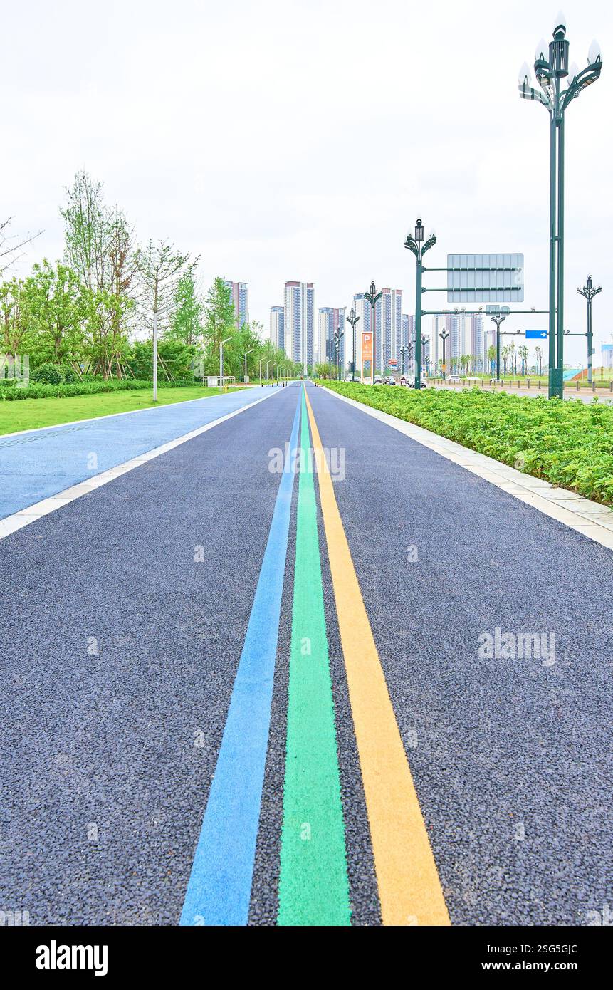 A bicycle lane with three lines: blue, green and yellow Stock Photo - Alamy