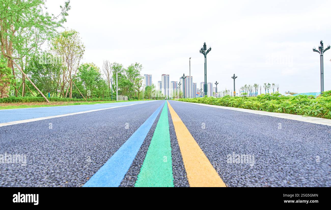 A bicycle lane with three lines: blue, green and yellow Stock Photo - Alamy