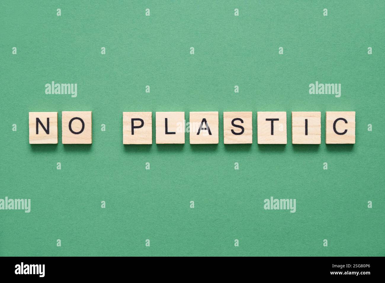 Wooden pieces with letters form, on a green background, a message of ...