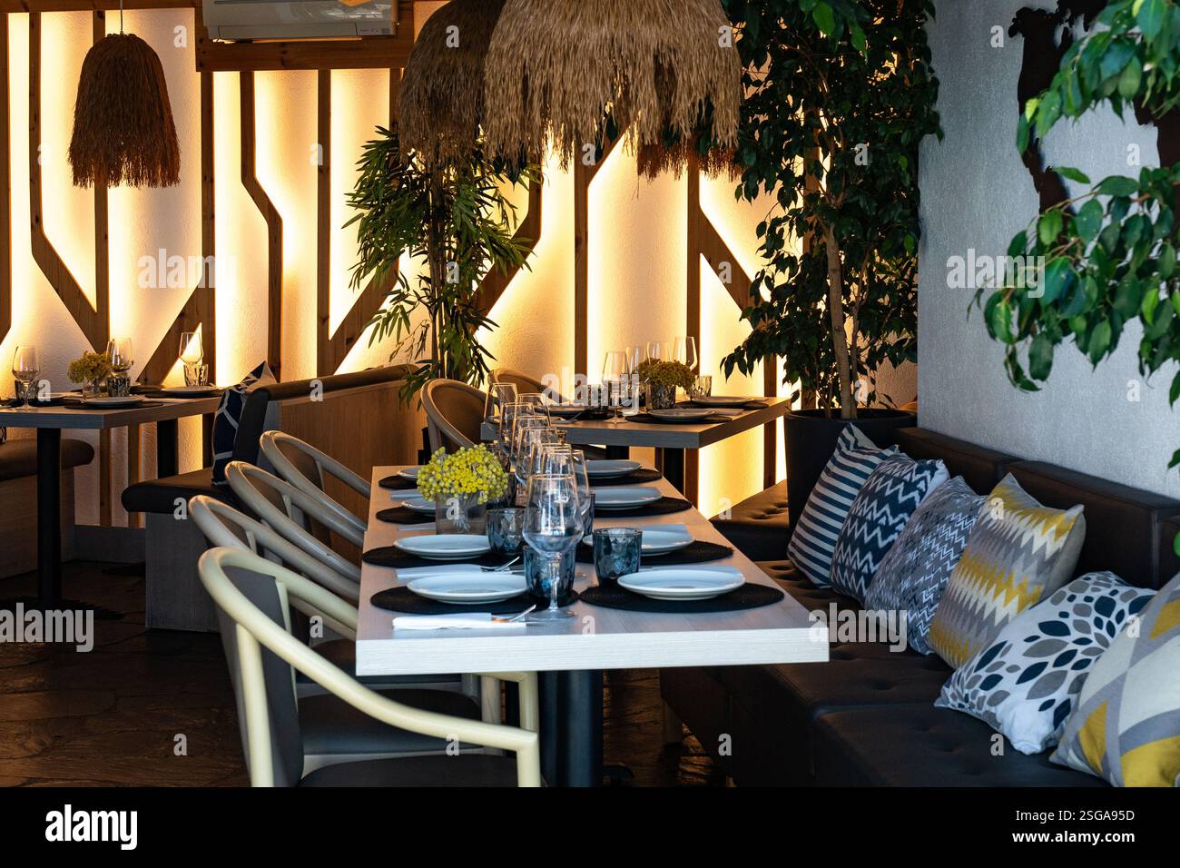 interior of a restaurant with set table and comfy bench with pillows ...