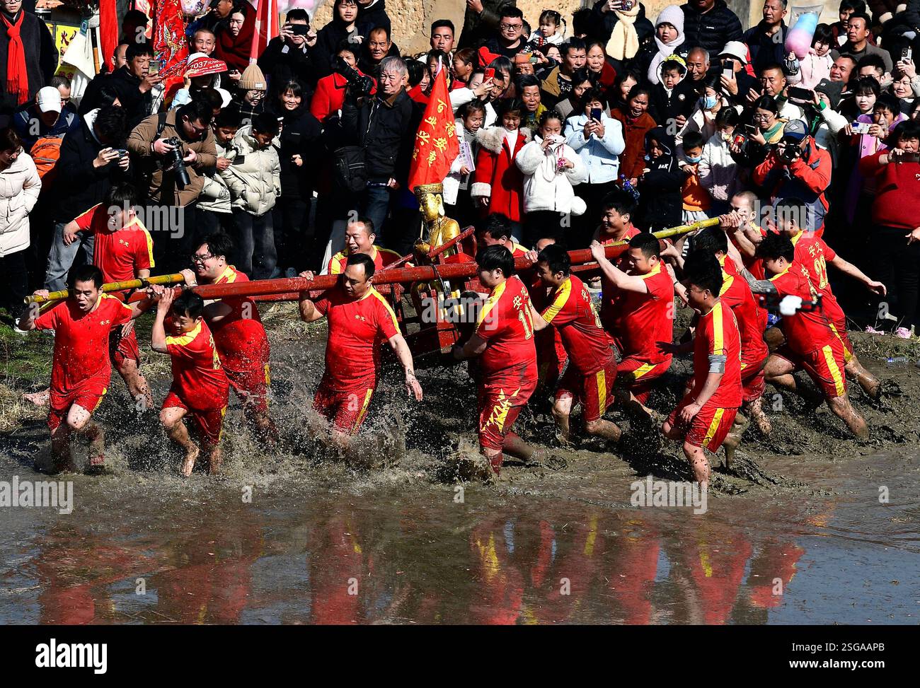 Longyan,China.9th February 2025. Hakka villagers carrying a statue run ...