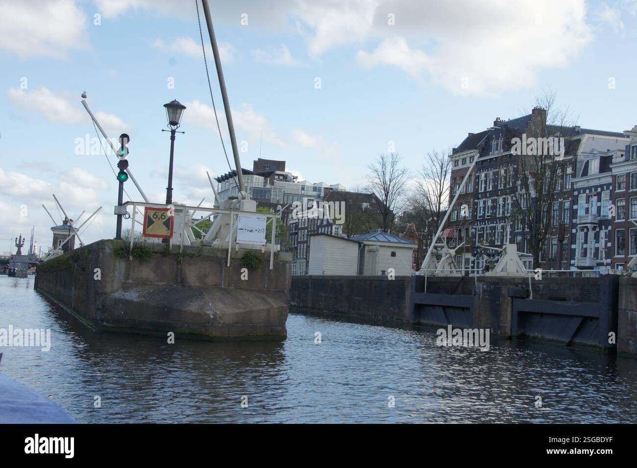 Amsterdam's scenic waterway with a bridge. A green traffic light hangs ...