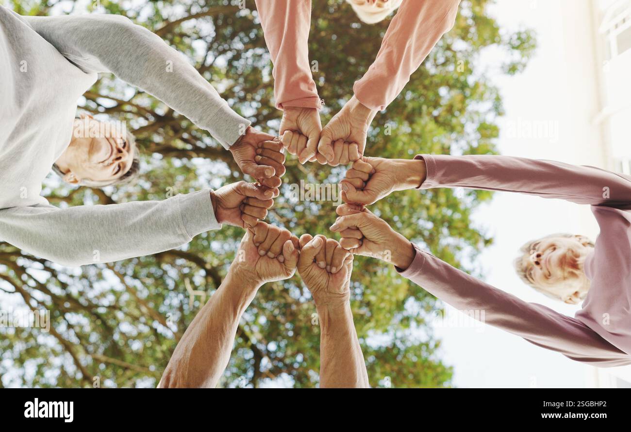 Outdoor, senior people and fist with huddle for fitness, support and ...