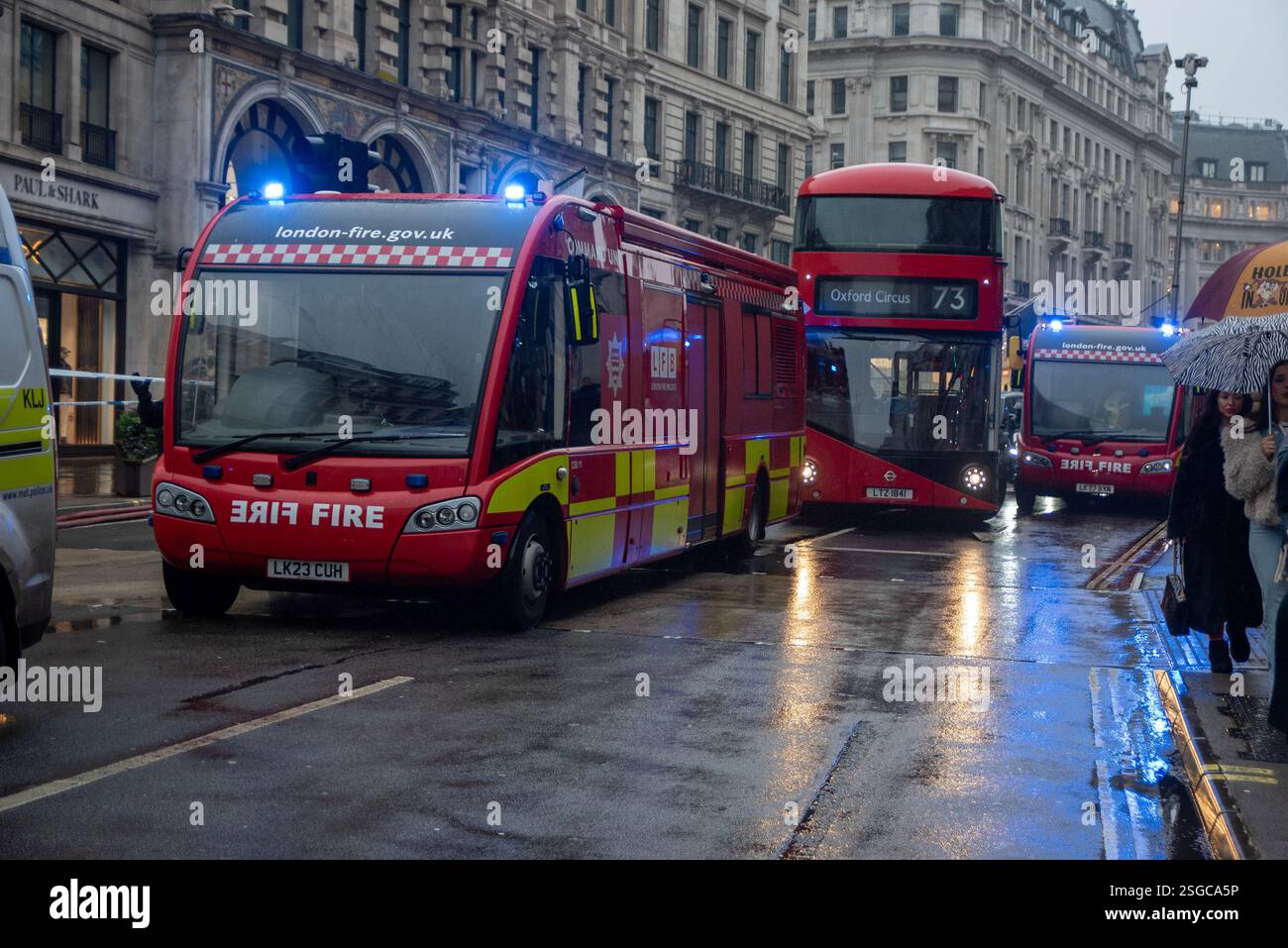A double decker bus tries to pass in between two London Fire Brigade's ...