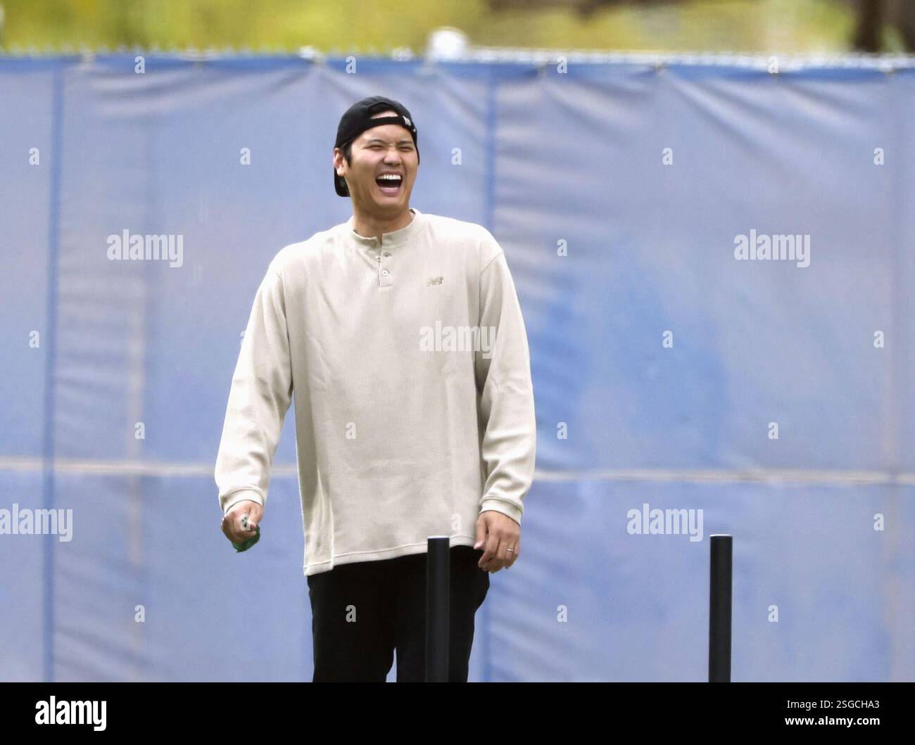 Shohei Ohtani of the Los Angeles Dodgers laughs while playing with his ...