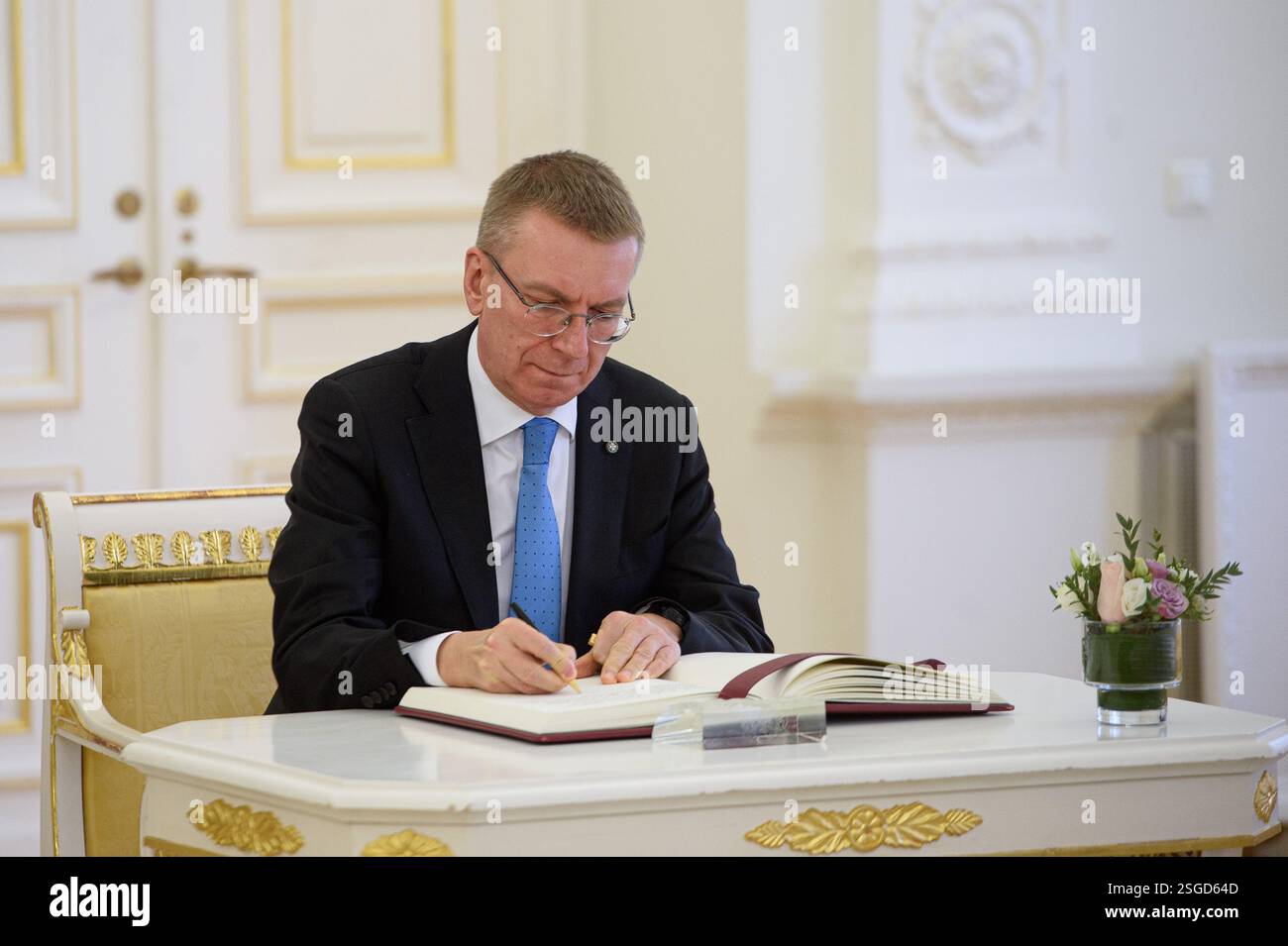 Latvian President Edgars Rinkevics signs the commemorative book at the ...