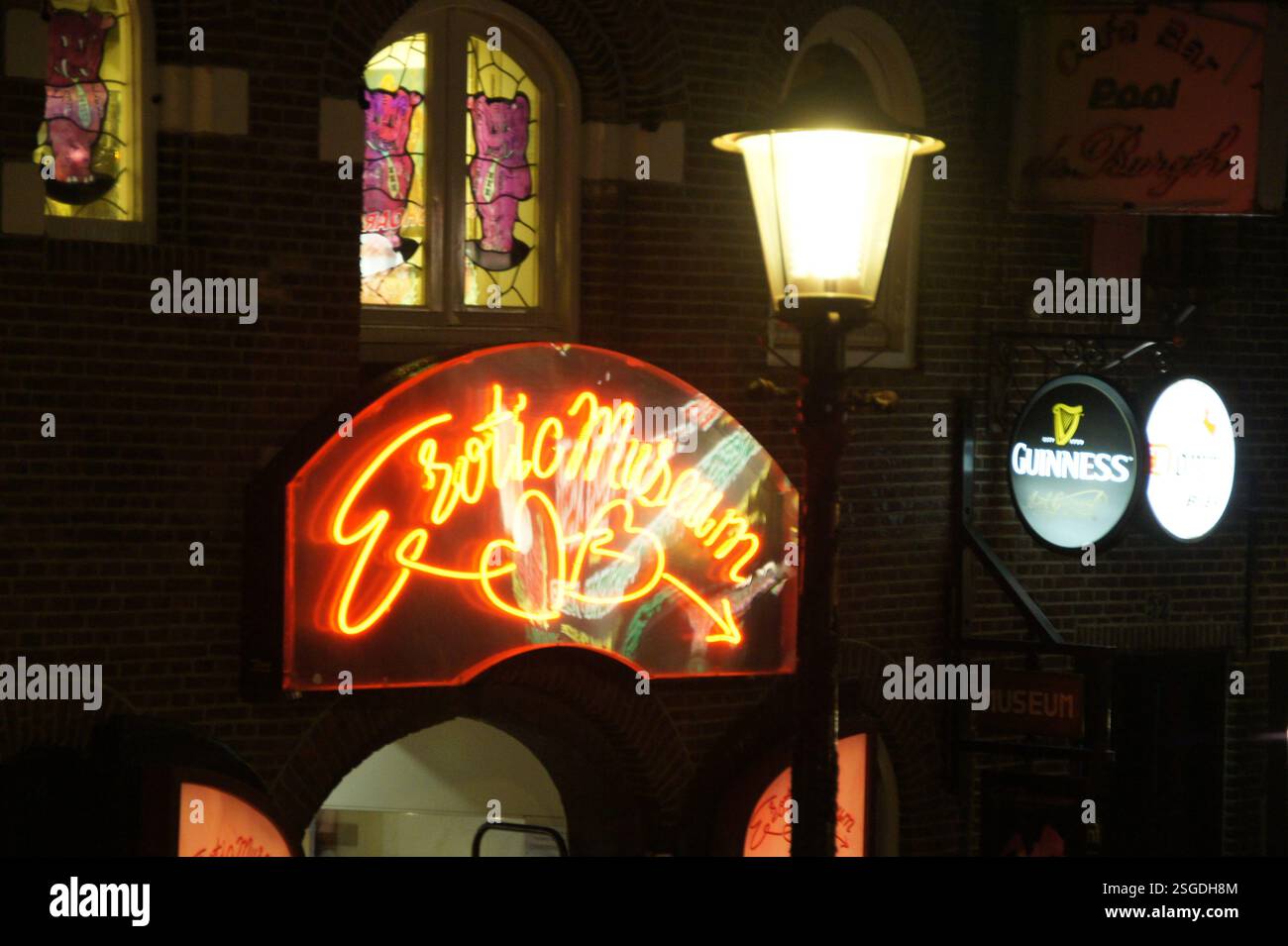 Illuminated neon signs in Amsterdam advertise a bar, pool, Guinness ...