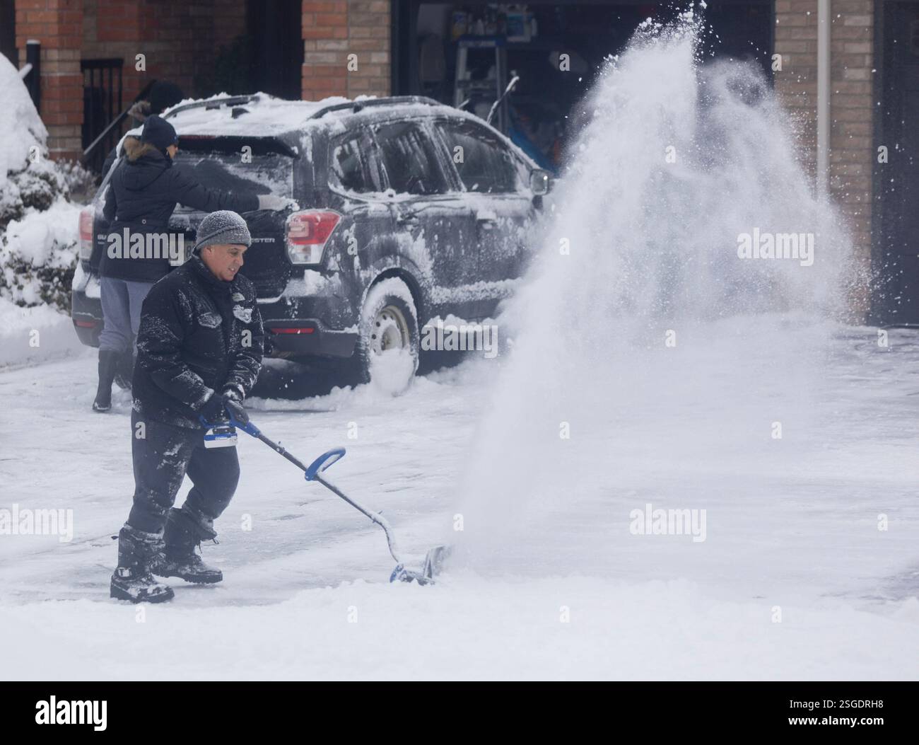 Toronto, Canada. 9th Feb, 2025. A man clears snow in Oakville, the ...