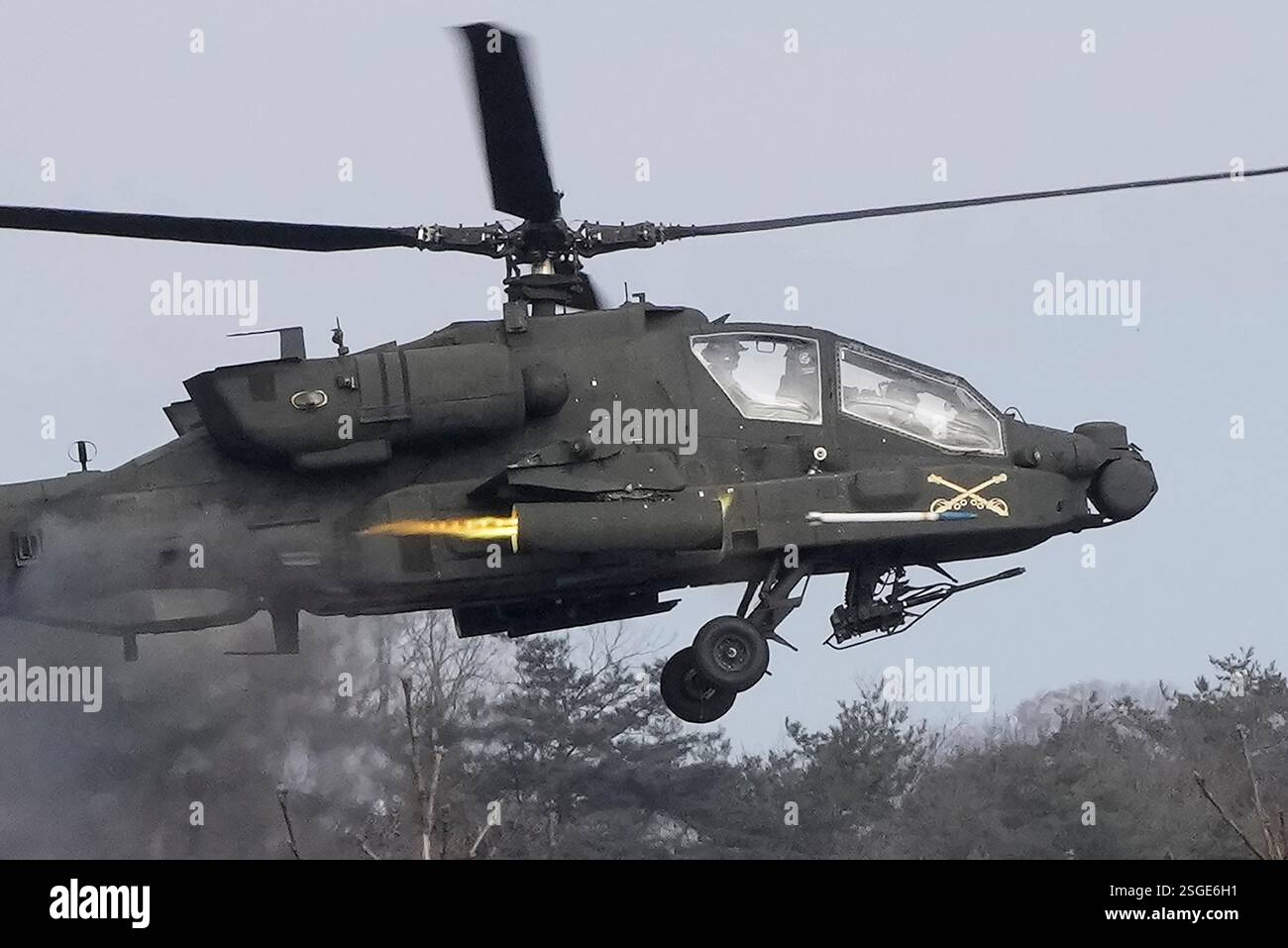 A U.S. Army AH-64 Apache helicopter fires a rocket during a combined ...