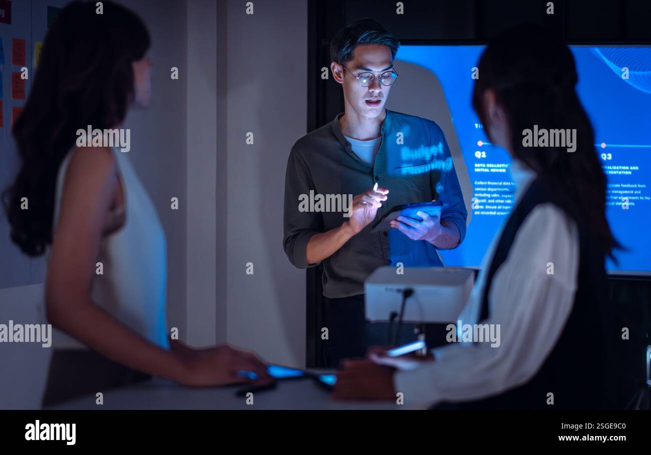 asian leader present business presentation in a dimly lit office ...