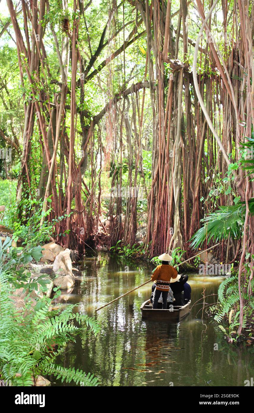 Tourist attraction boat ride through forest river canal, Asia. Tourists ...