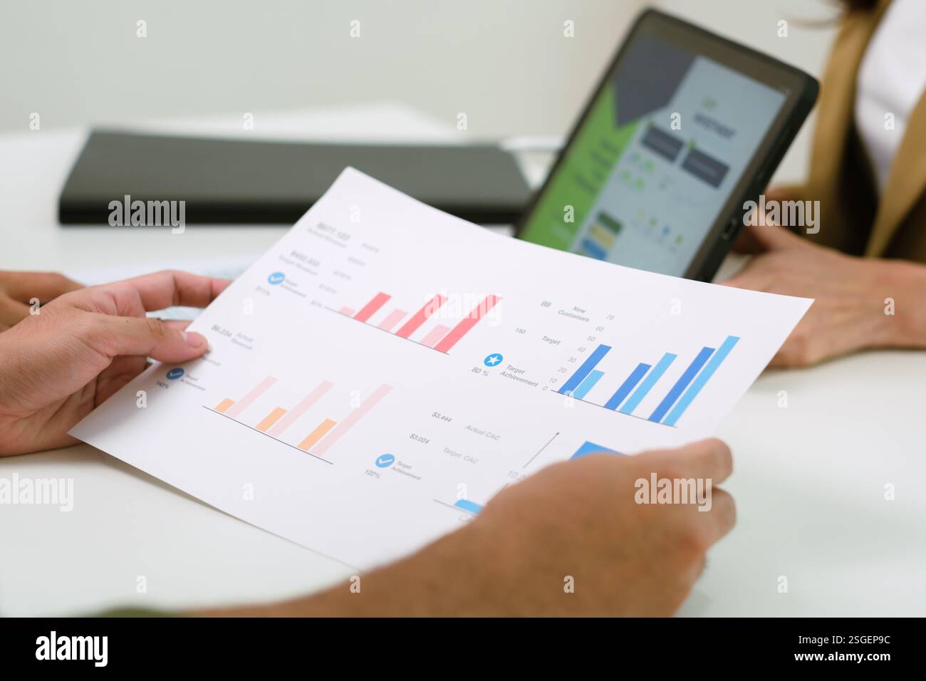 asian financial advisor presenting charts and data on a tablet during ...
