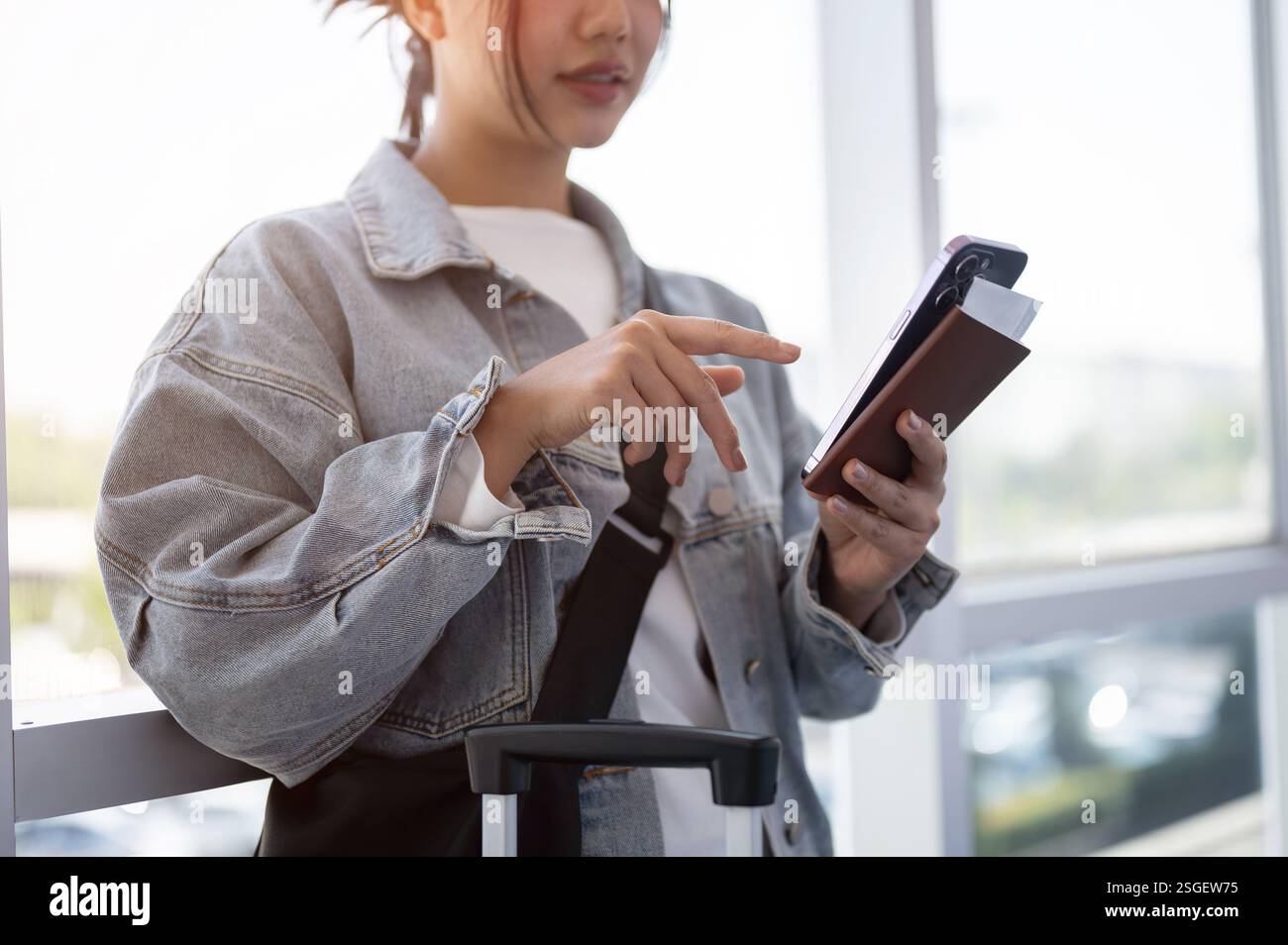 A close-up of an Asian female passenger waiting for her flight boarding ...