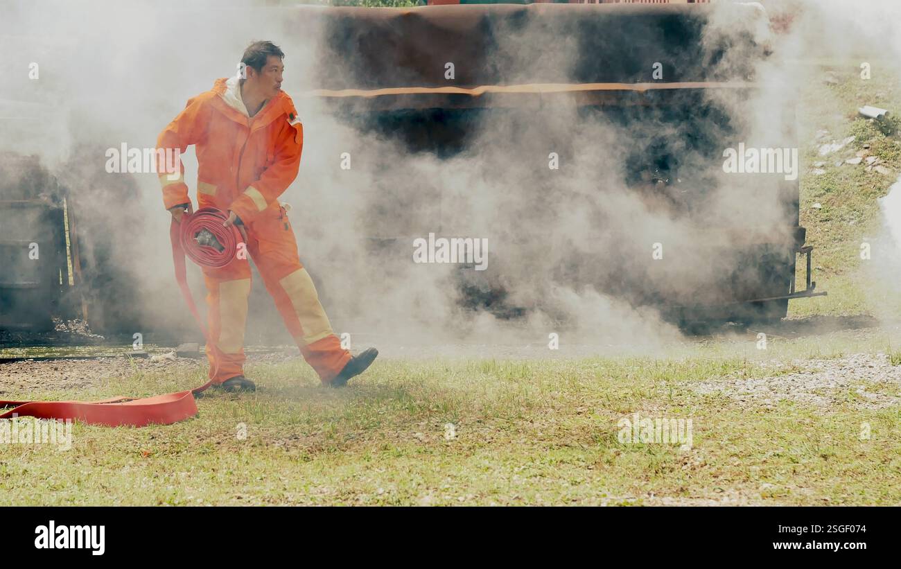 Firefighter fighting with flame using fire hose chemical water foam ...