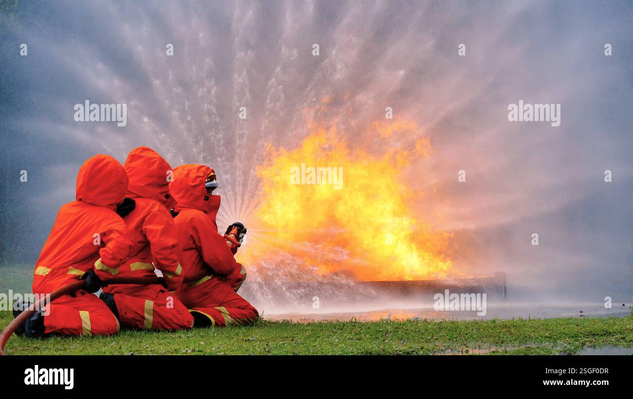 Firefighter fighting with flame using fire hose chemical water foam ...