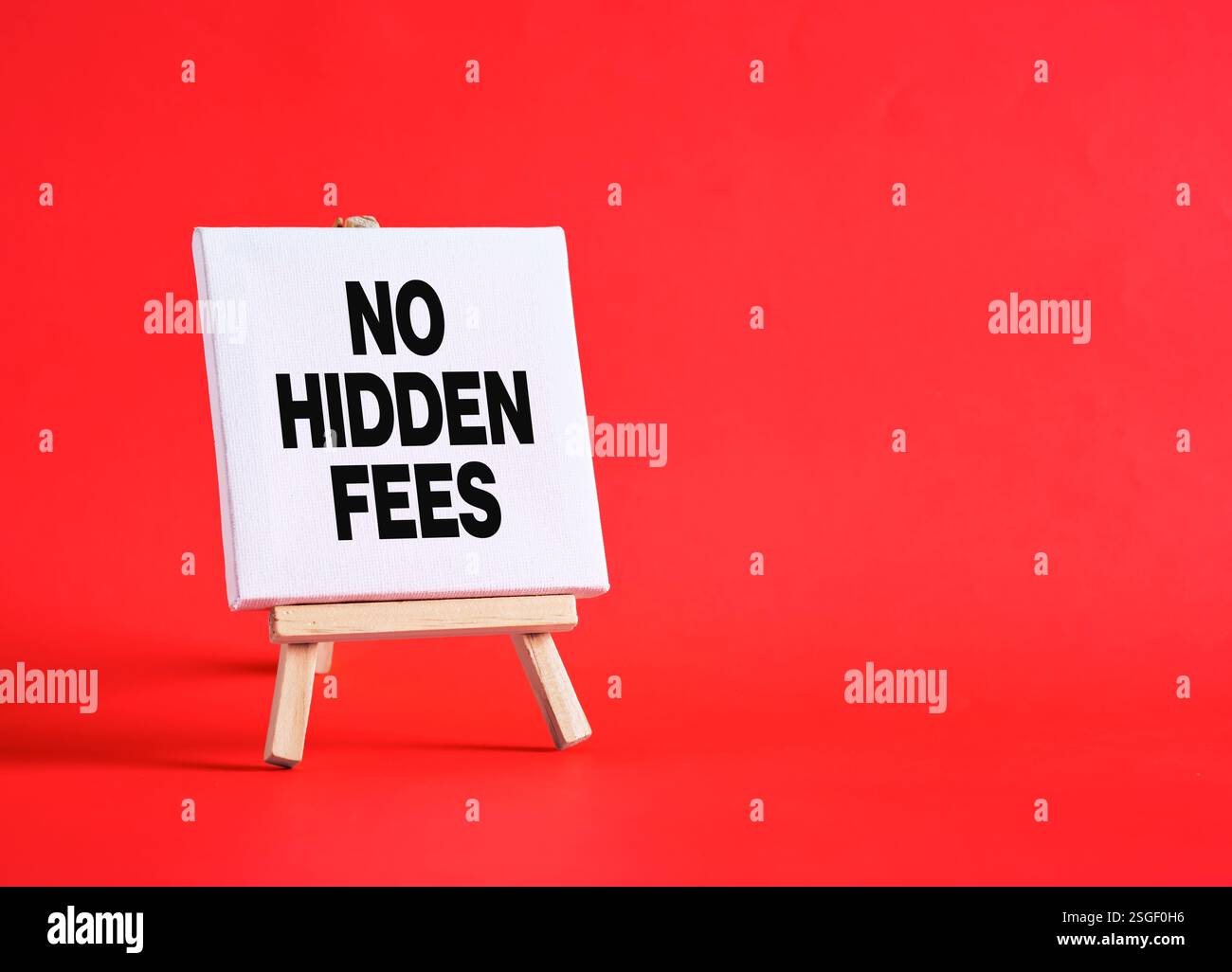 Small white canvas on wooden easel showing no hidden fees on red ...