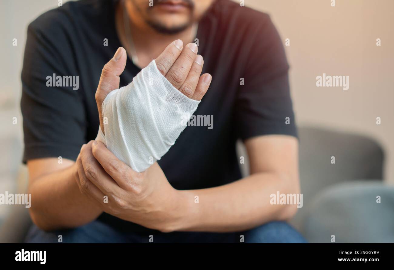 Man with a gauze bandage wrapped around his hand. First aid, accident ...