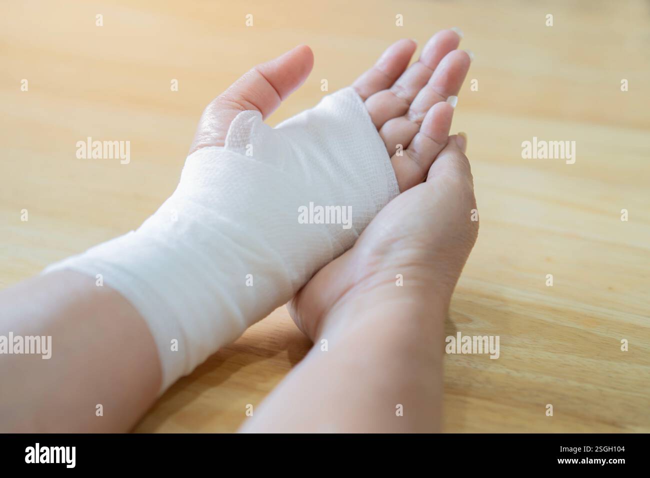Old woman with gauze bandage wrapped around her injured hand over ...