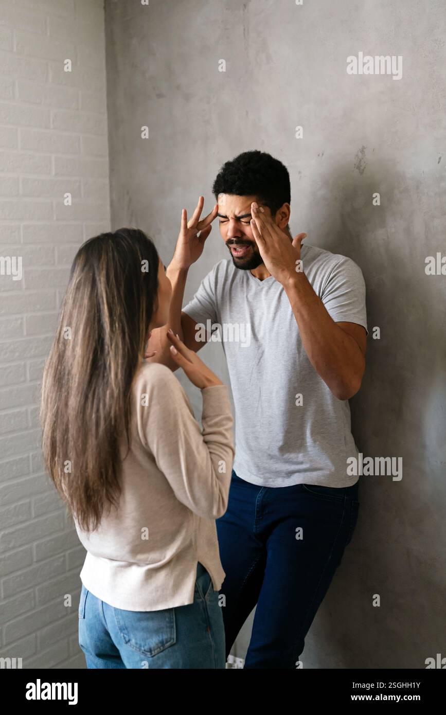 Husband and wife are arguing at home. Angry man is yelling at his wife ...
