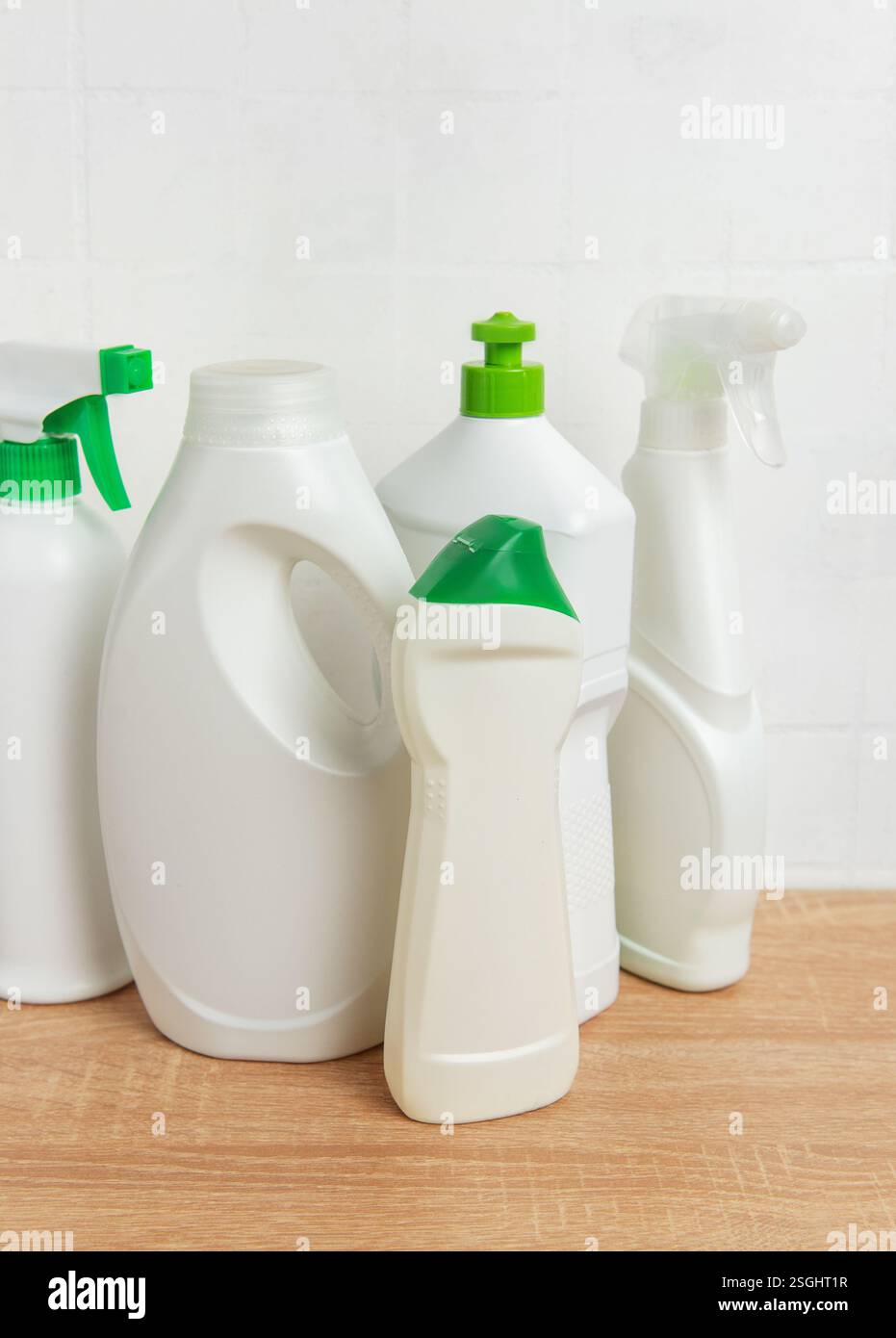Plastic bottles of cleaning products and detergents standing on wooden ...